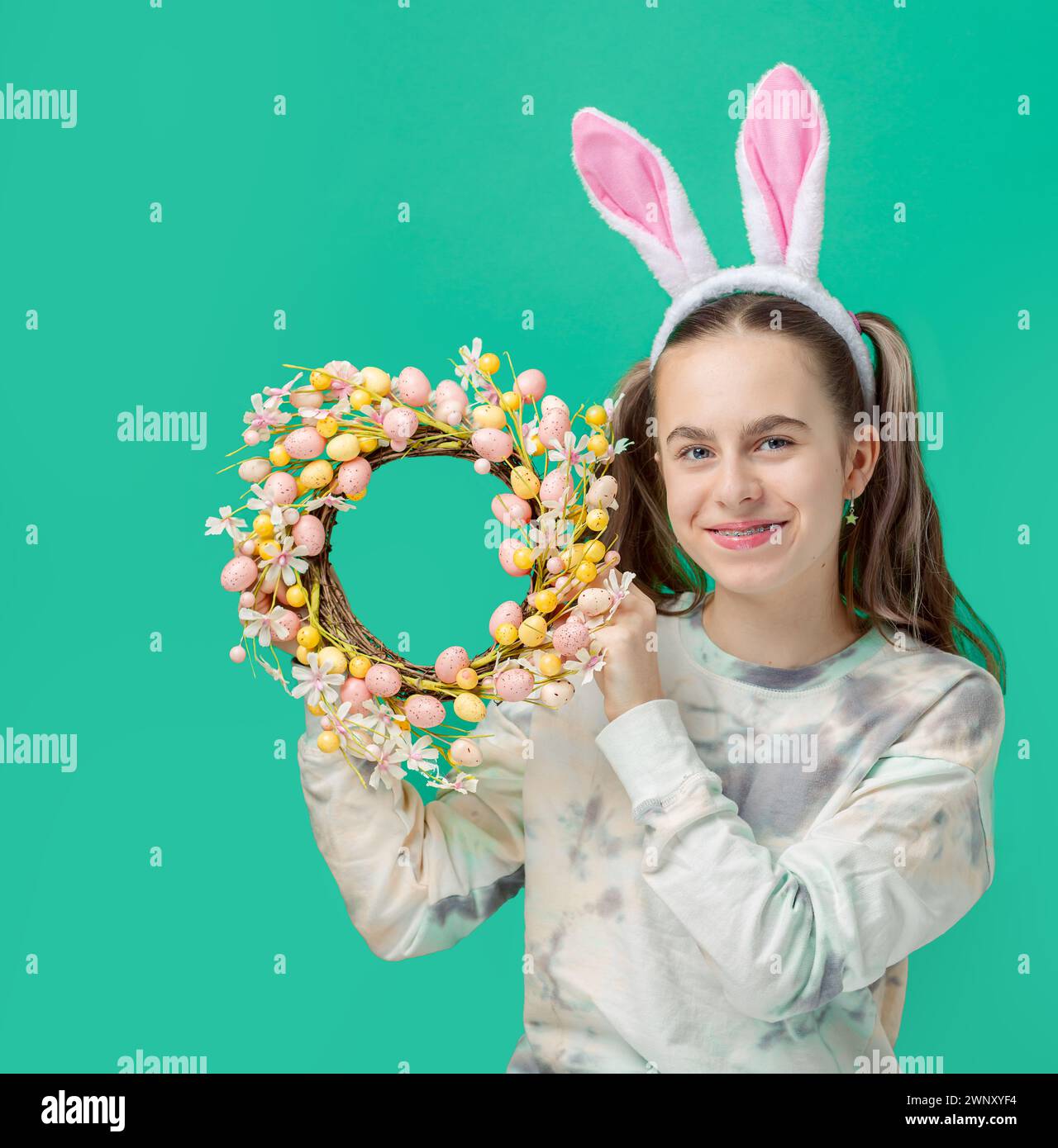 Happy Easter. Girl with joyful smile, in shiny pink rabbit ears and ...