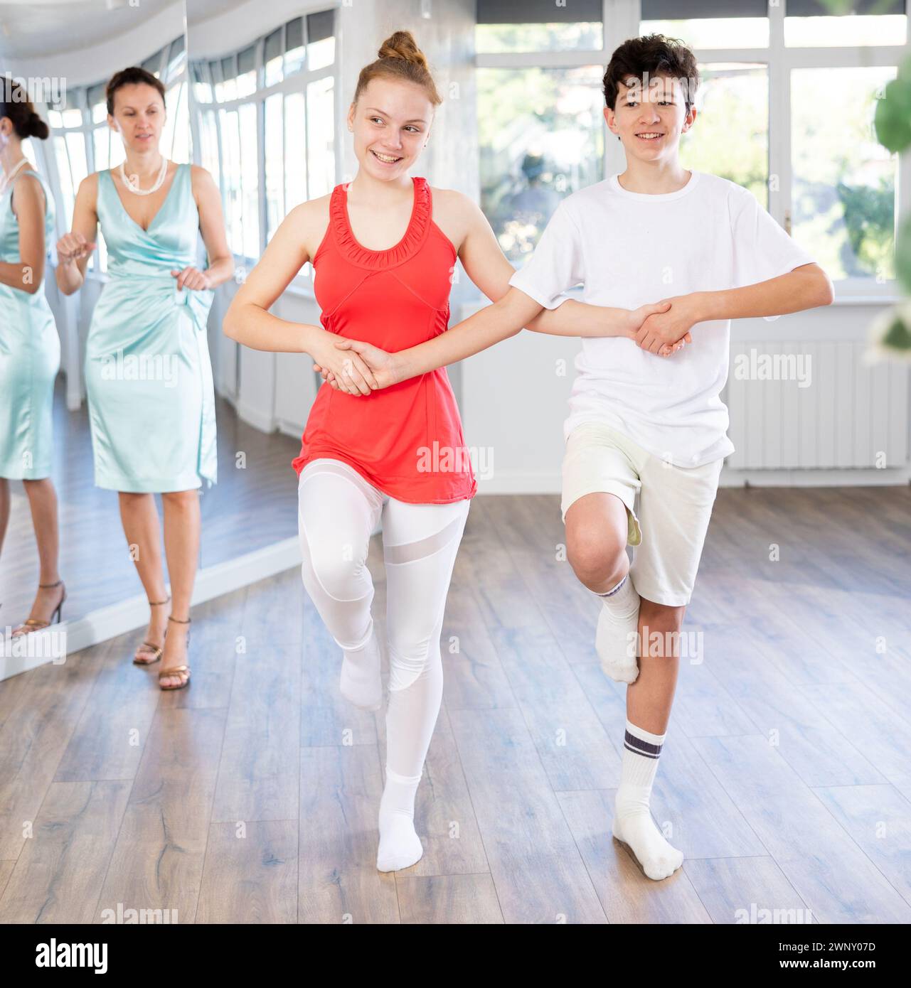 Smiling teenage boy and girl practicing cheerful polka at dance lesson Stock Photo - Alamy