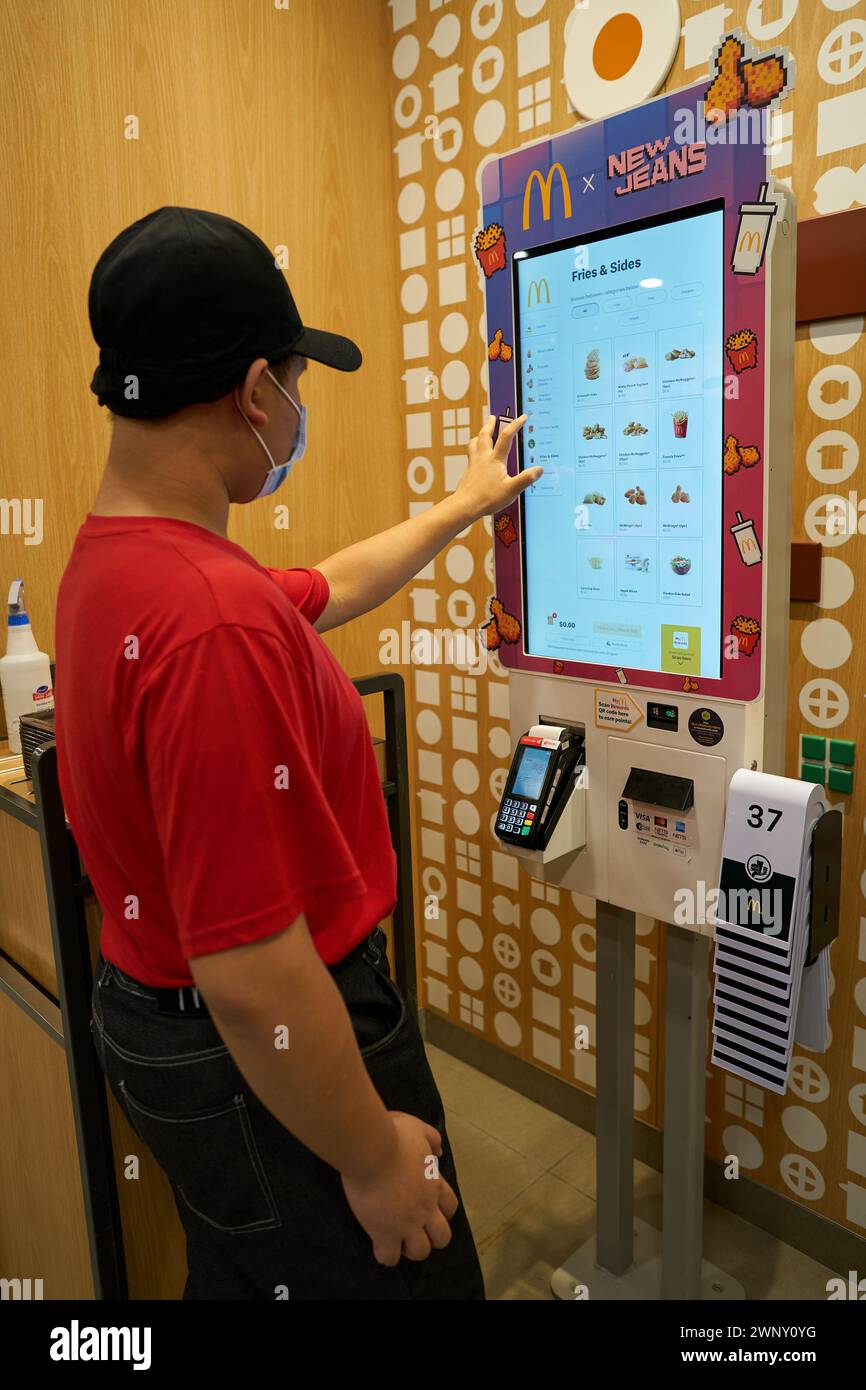 SINGAPORE - NOVEMBER 06, 2023: a man use self-service kiosk inside ...