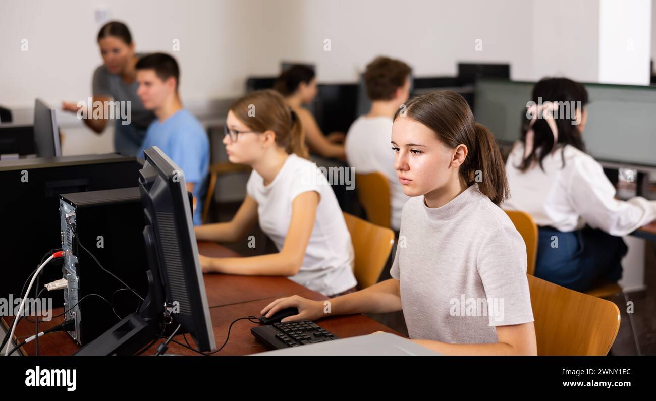Smart female teenager learning computer science while she is using a PC ...