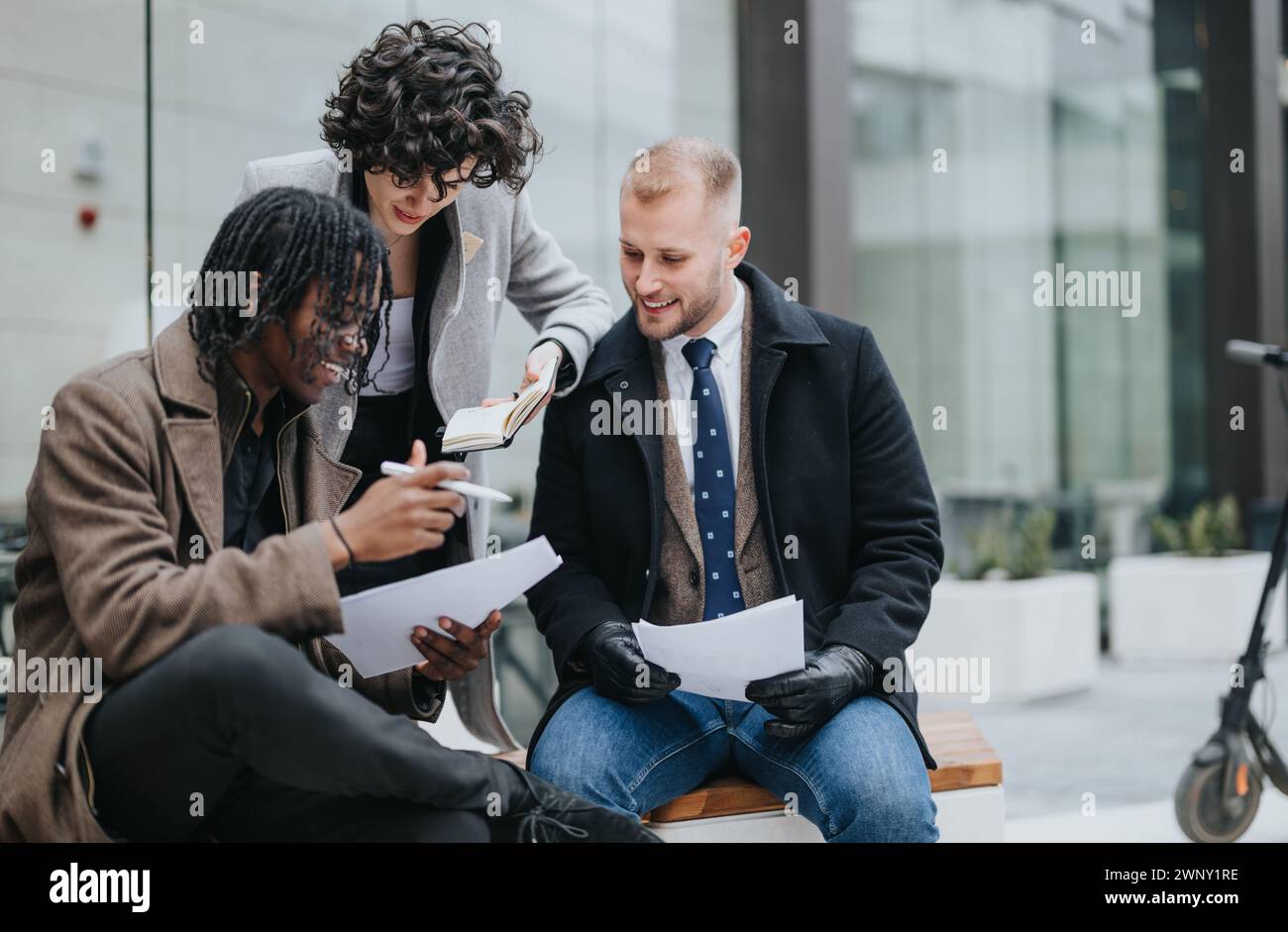 Multicultural business team working together outside office building ...