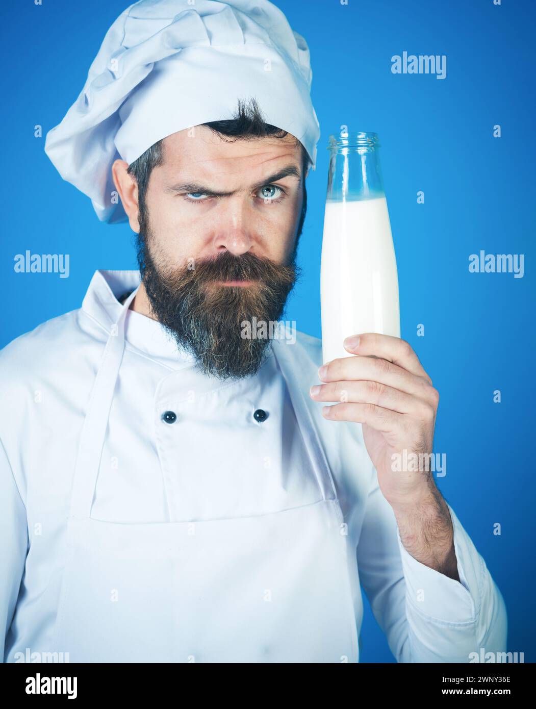 Dairy farmer products. Professional male chef in white apron with glass ...