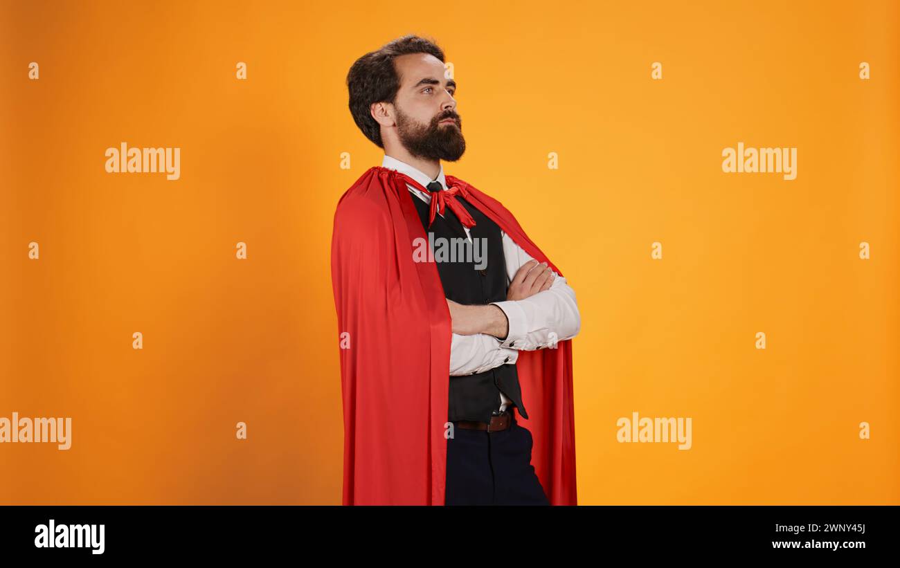 Powerful comic superhero with red cape standing against yellow ...