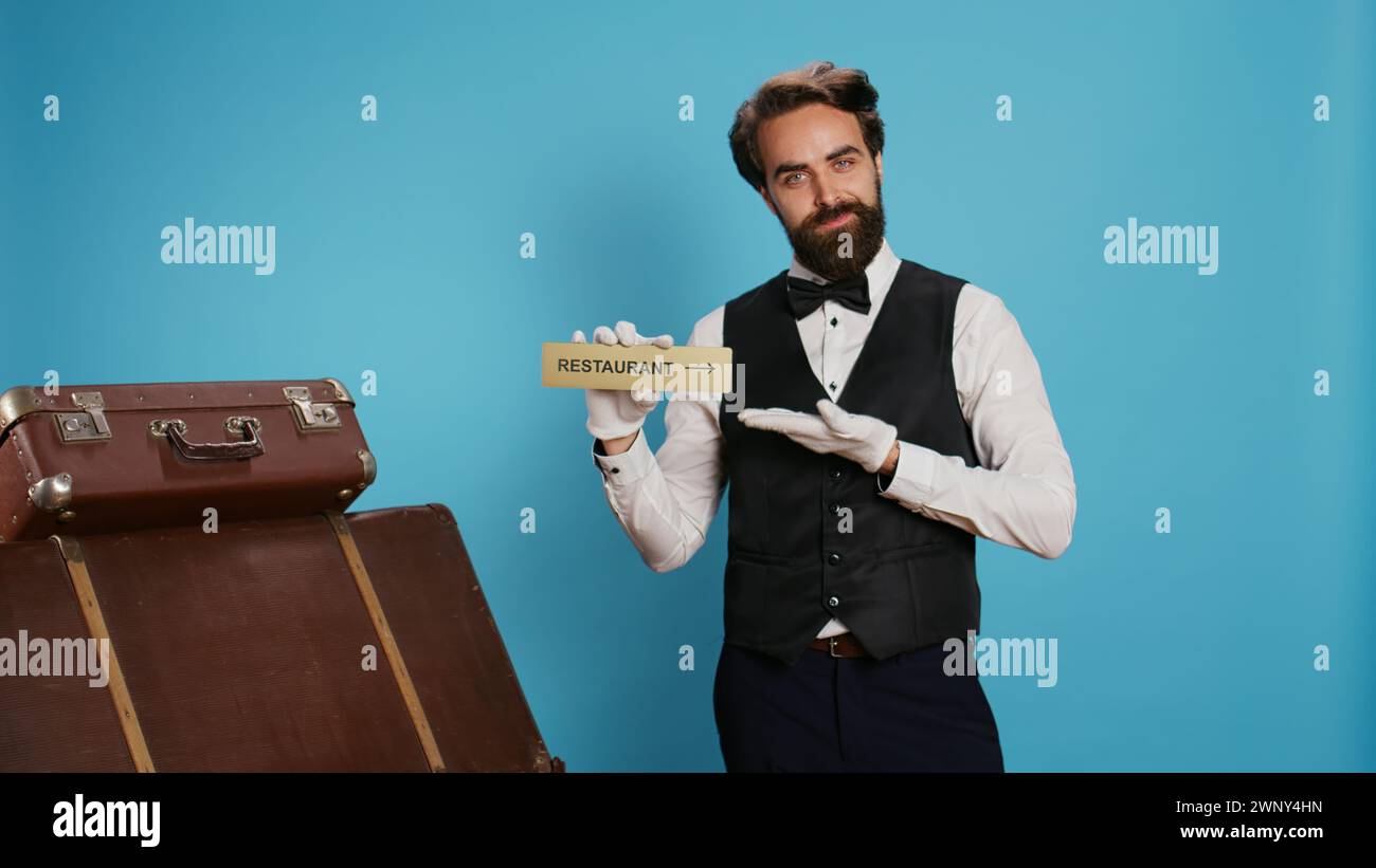 Hotel porter advertises restaurant sign to help travellers with ...