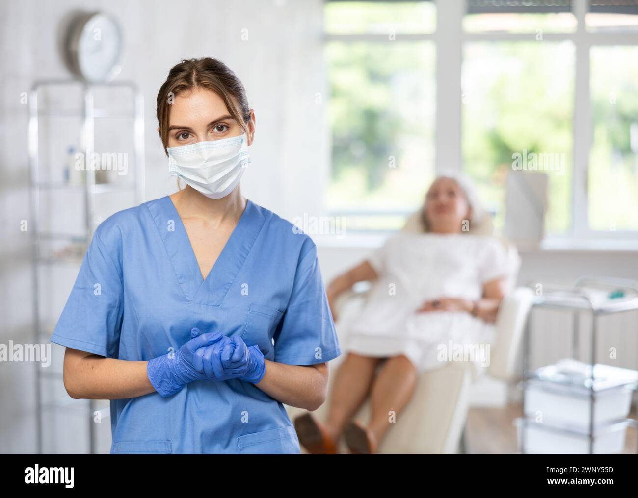 Happy doctor or nurse with mask in uniform with crossed arm, patient ...