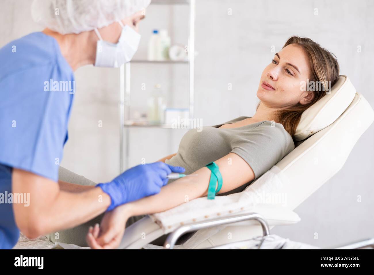 Elderly doctor drawing blood from young patient Stock Photo - Alamy