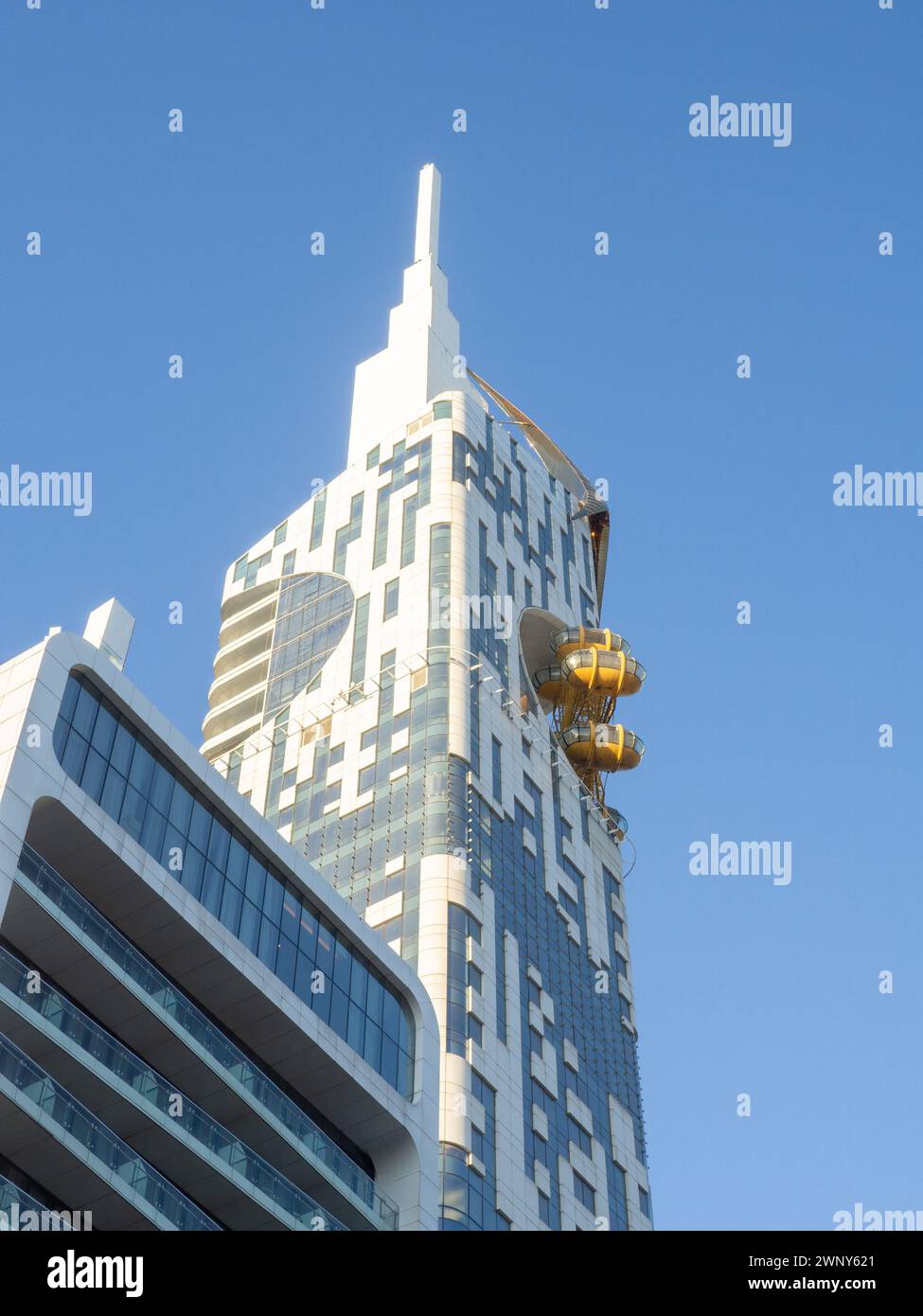 A tall building with a spire and a carousel. Architecture of Batumi ...