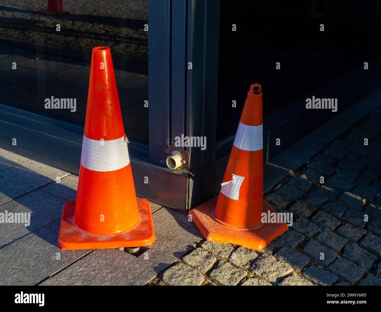 Traffic cones on paving stones. Traffic regulation. Parking. Orange ...