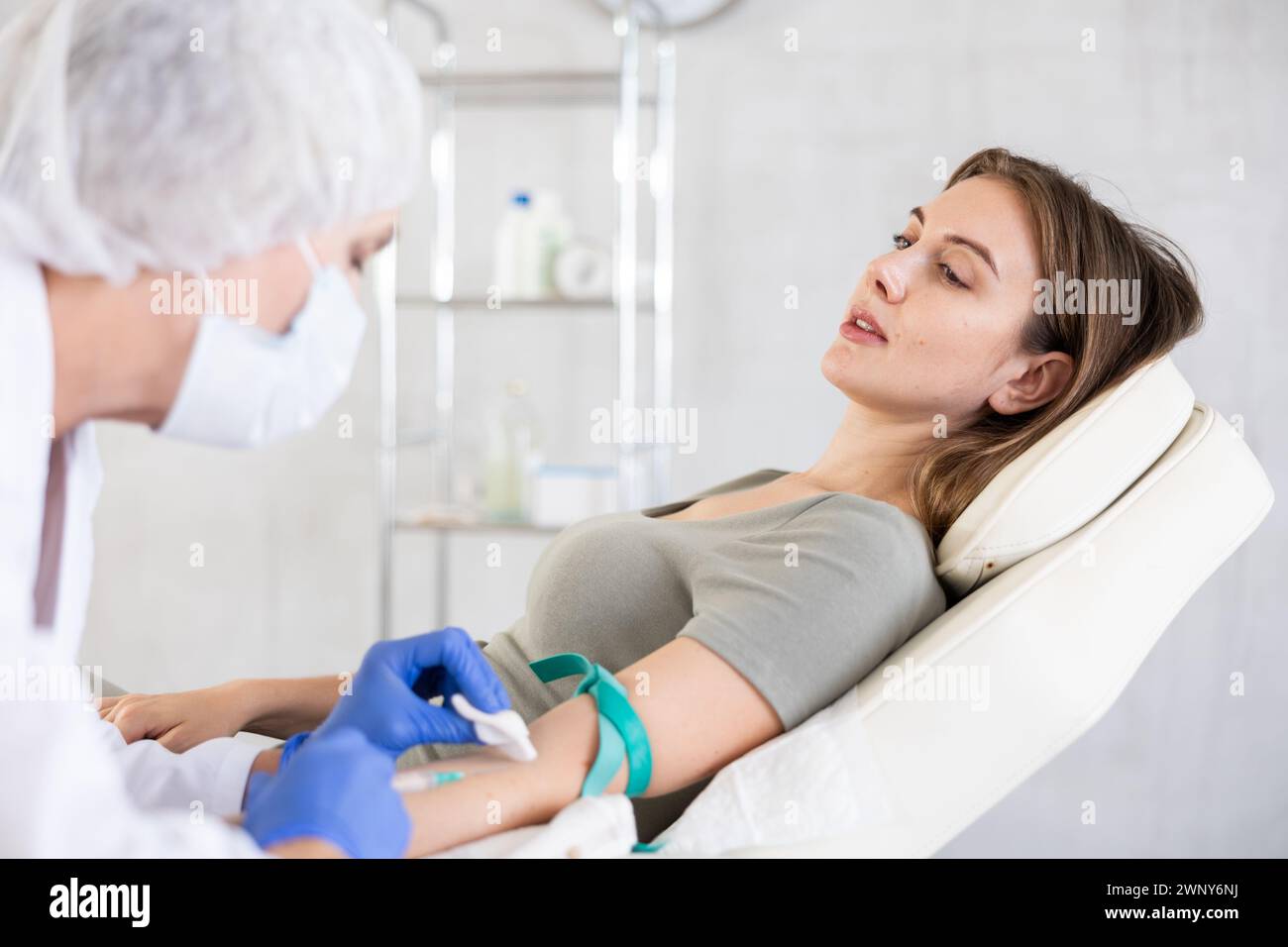 Elderly doctor drawing blood from young patient Stock Photo - Alamy