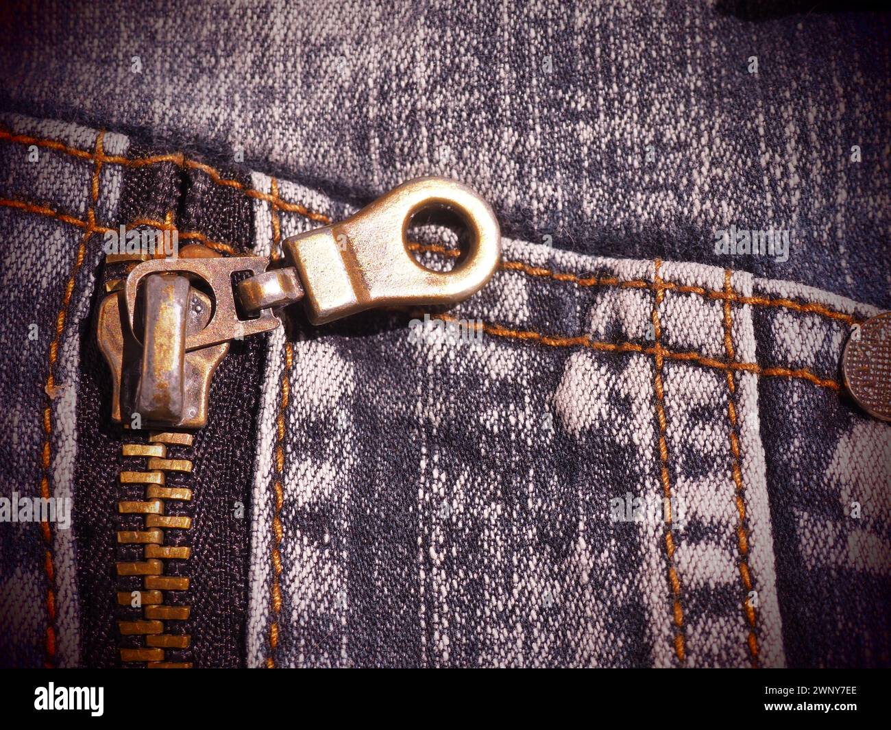 Close-up denim with seams and locks. Heavily shabby worn jeans. Metal ...