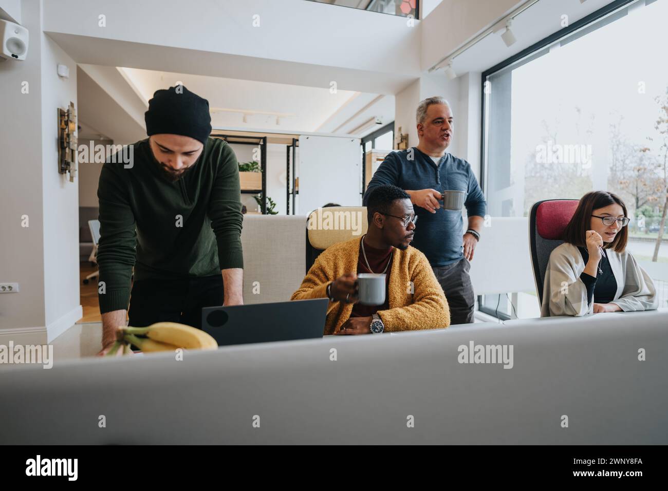 A multiethnic office team engages in a project discussion. Colleagues ...