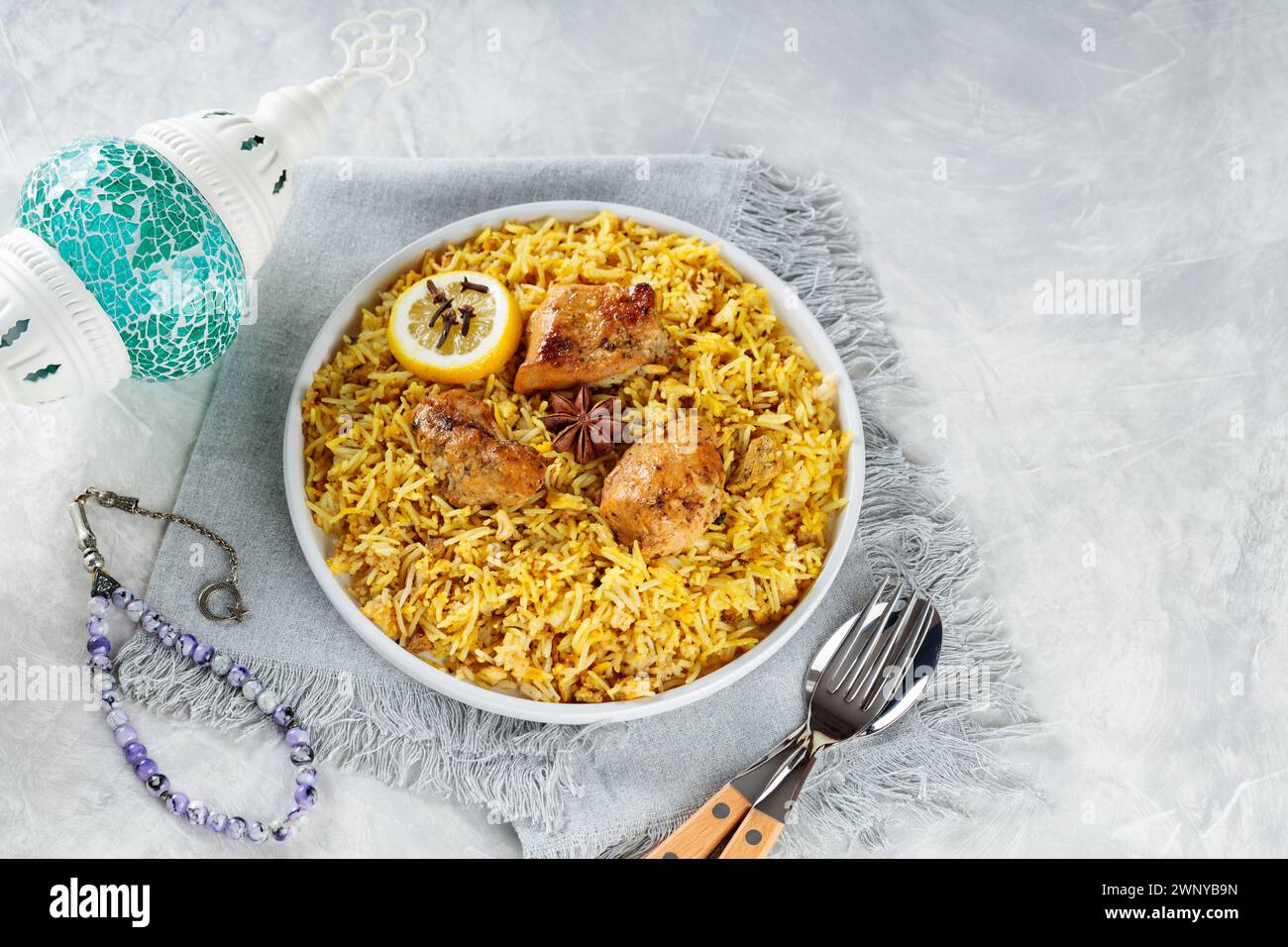 Chicken Biryani with Spices and Lemon on White Plate, Concrete ...