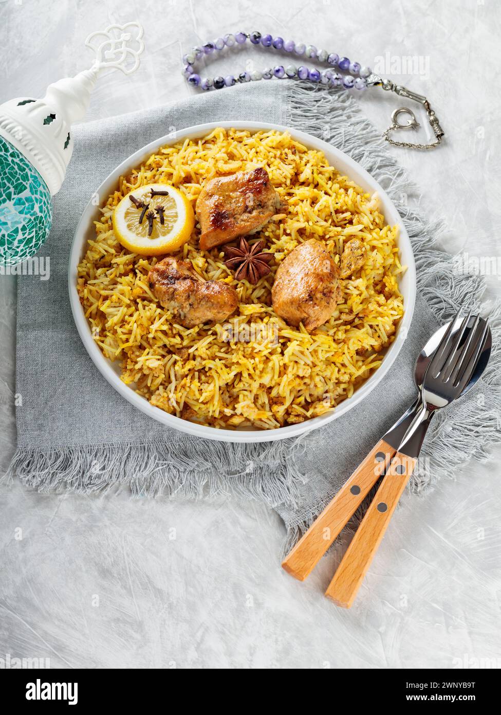 Chicken Biryani with Spices and Lemon on White Plate, Concrete ...
