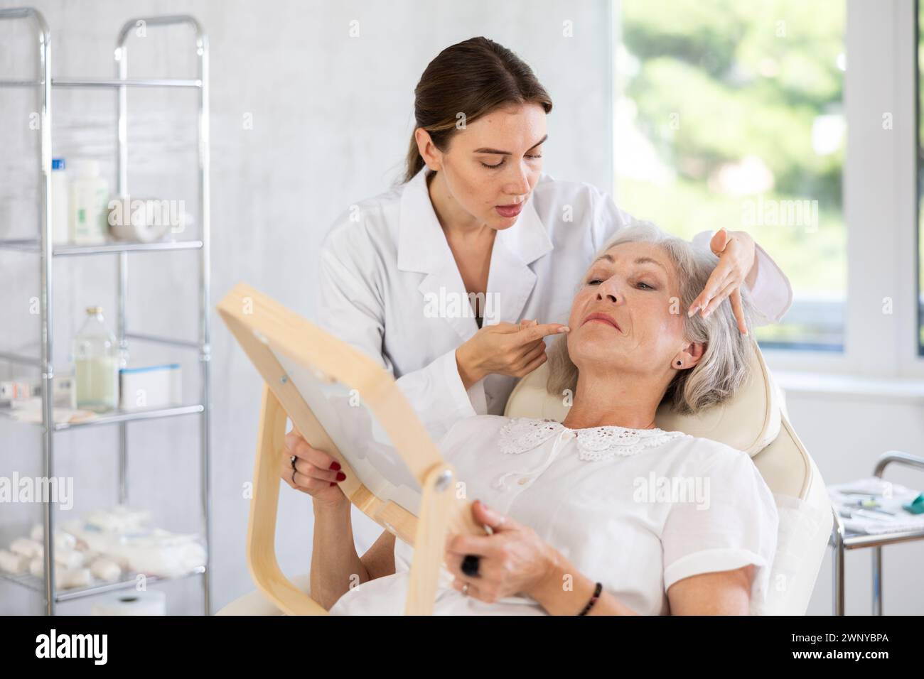 Mature patient with mirror Stock Photo - Alamy