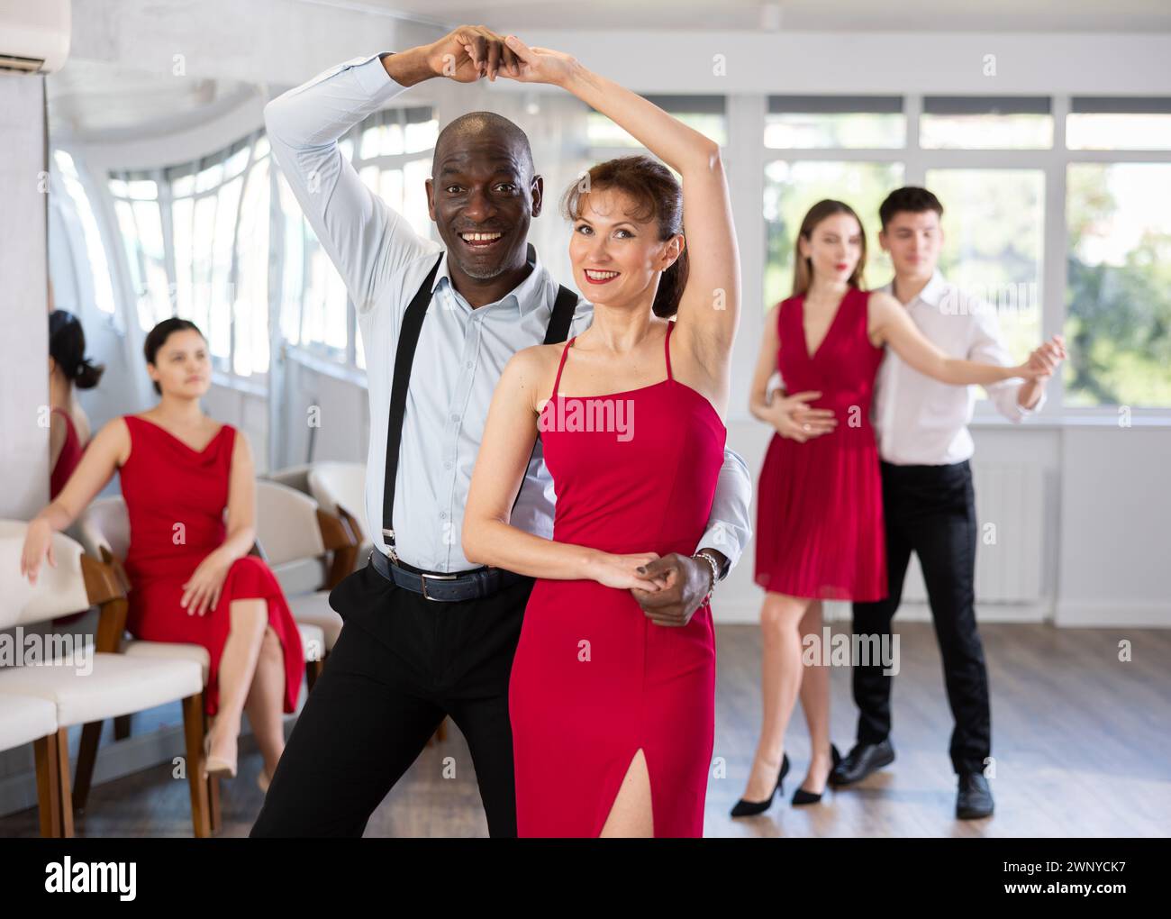 Young dancing multinational couple enjoying active swing dance in ...