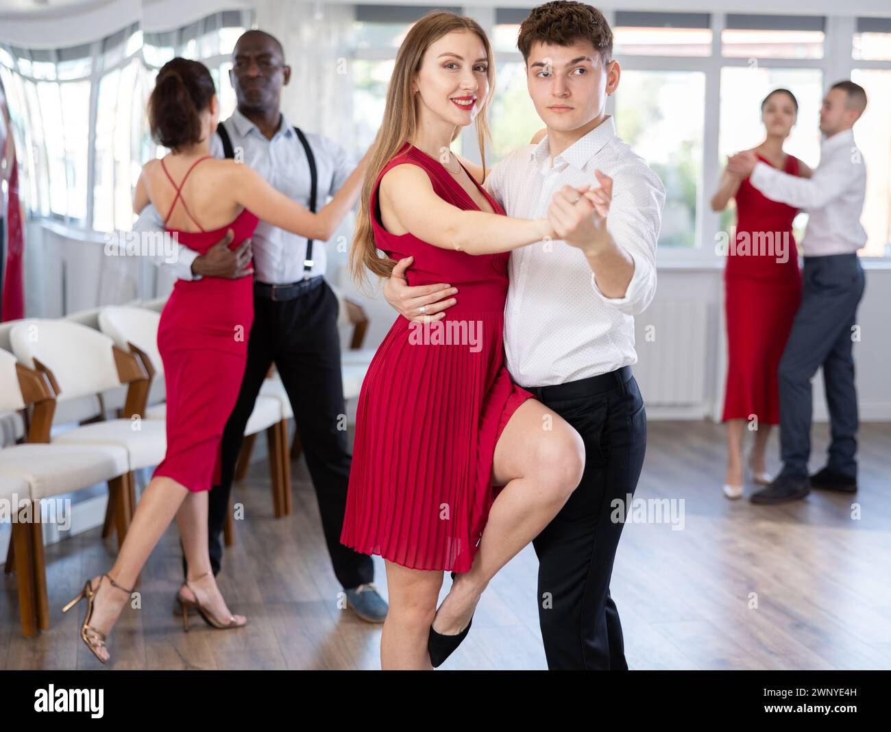 Young guy and graceful woman rehearsing elegant tango in pair Stock ...