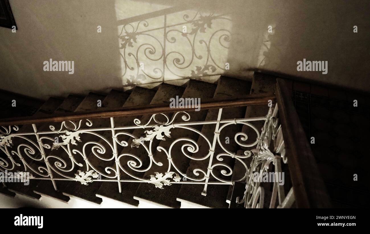 Mysterious staircase with a forged metal railing at night in the dark ...