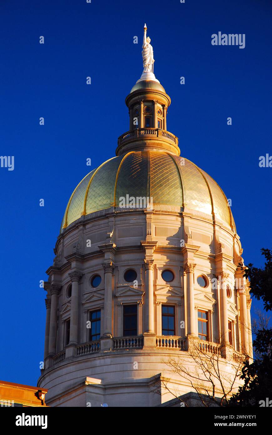 The gold dome of the Georgia State Capitol is set against the blue sky ...