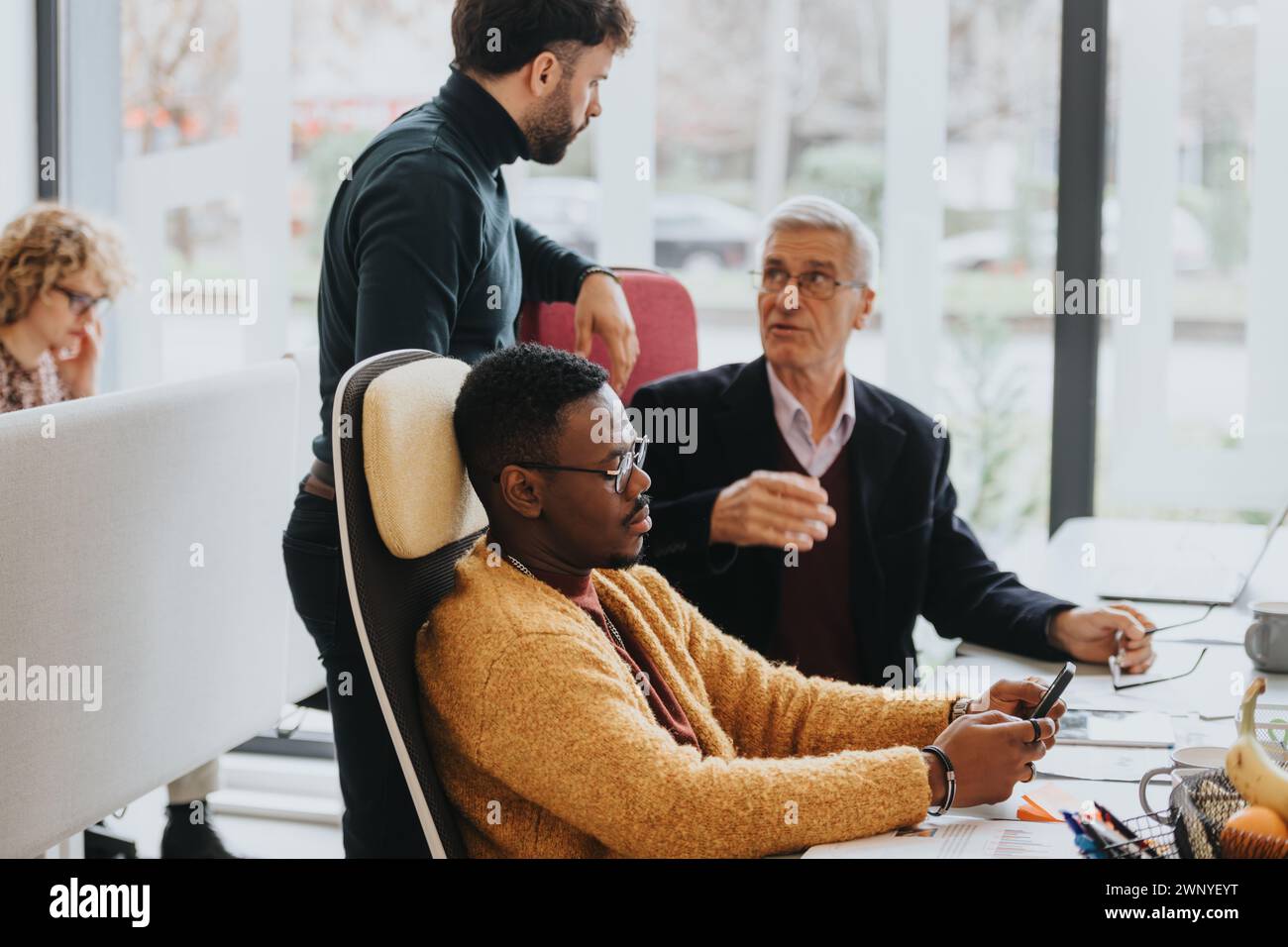 Multi generational, mixed race business colleagues engaged in a ...