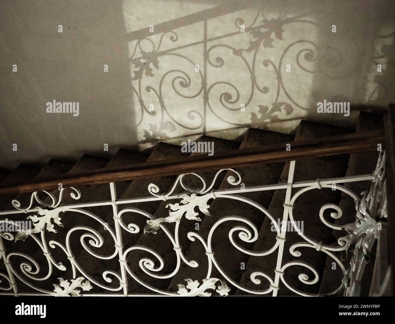 Mysterious staircase with a forged metal railing at night in the dark ...