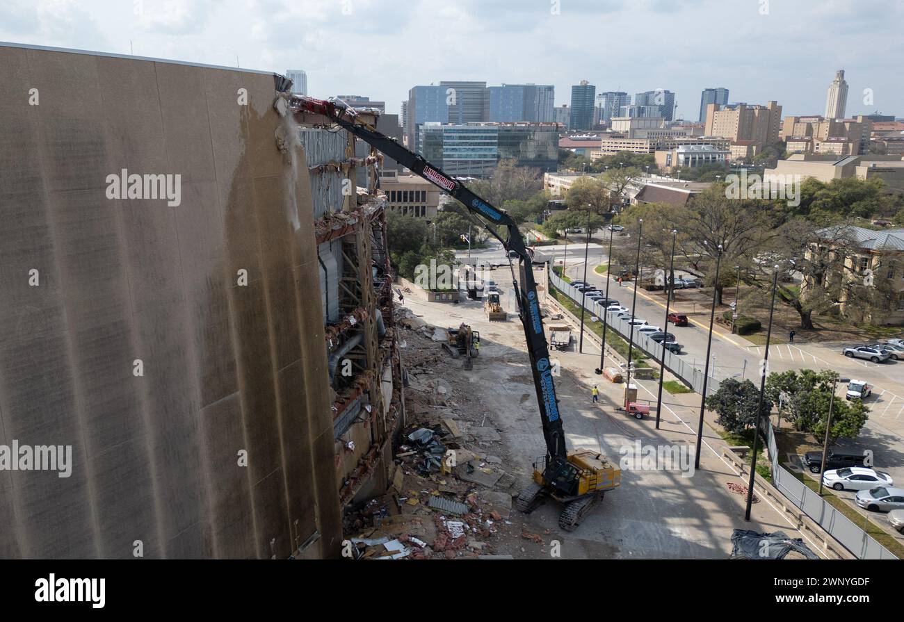 March 5, 2024: Work crews use a concrete crusher to remove the exterior wall structure as ...