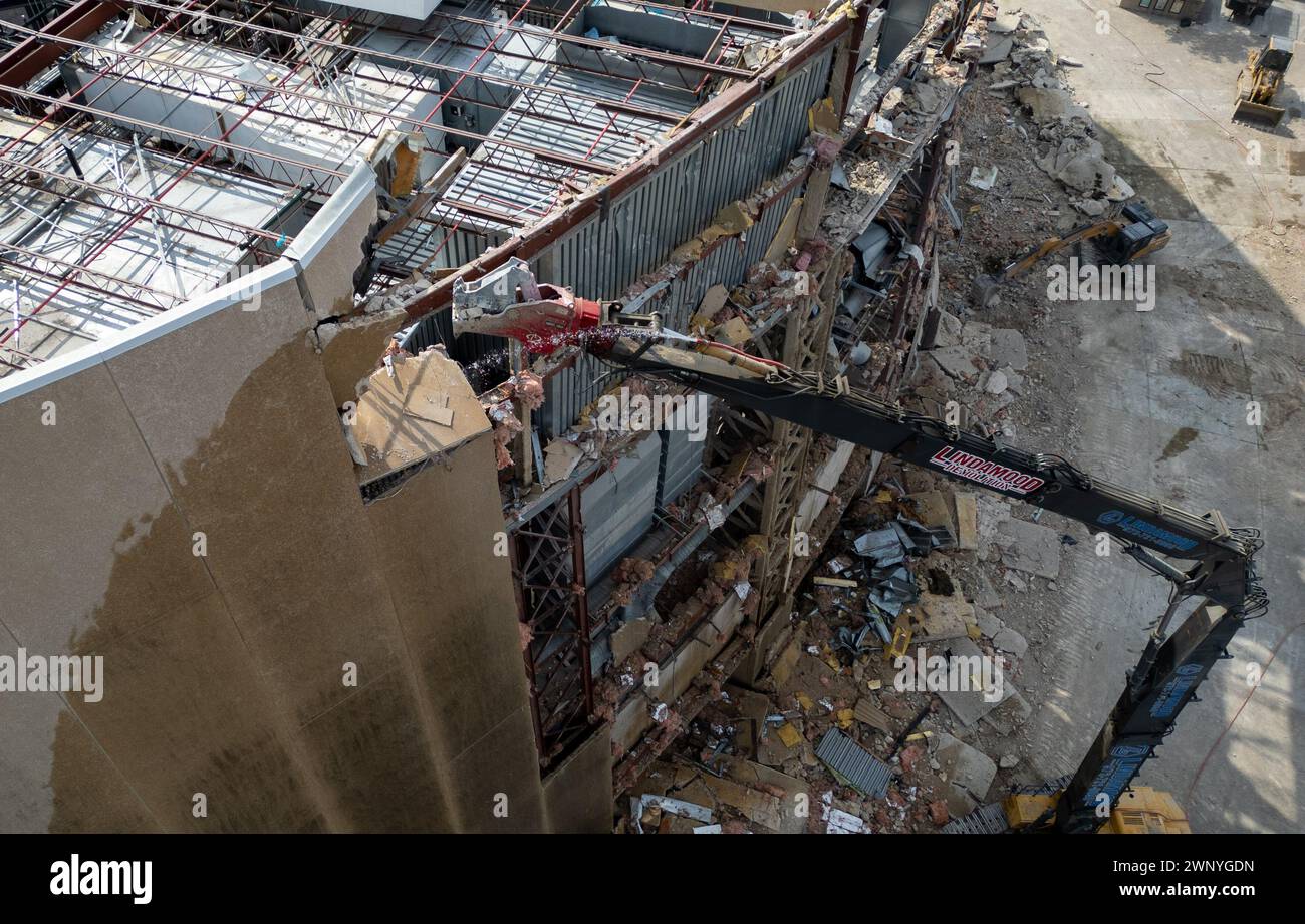 March 5, 2024: Work crews use a concrete crusher to remove the exterior wall structure as ...