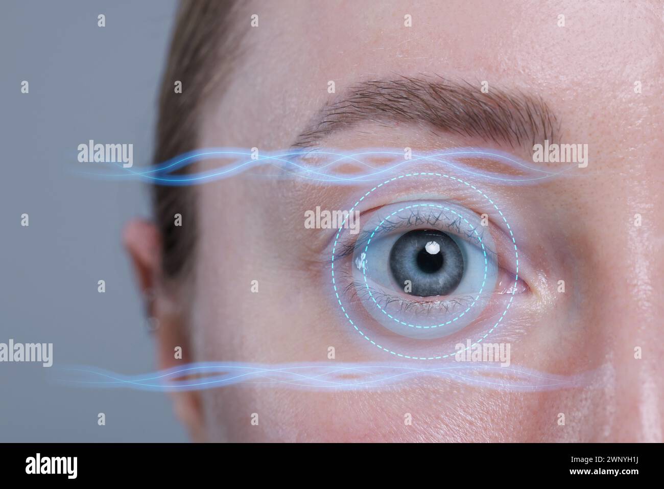 Vision test. Woman and digital scheme focused on her eye against grey ...