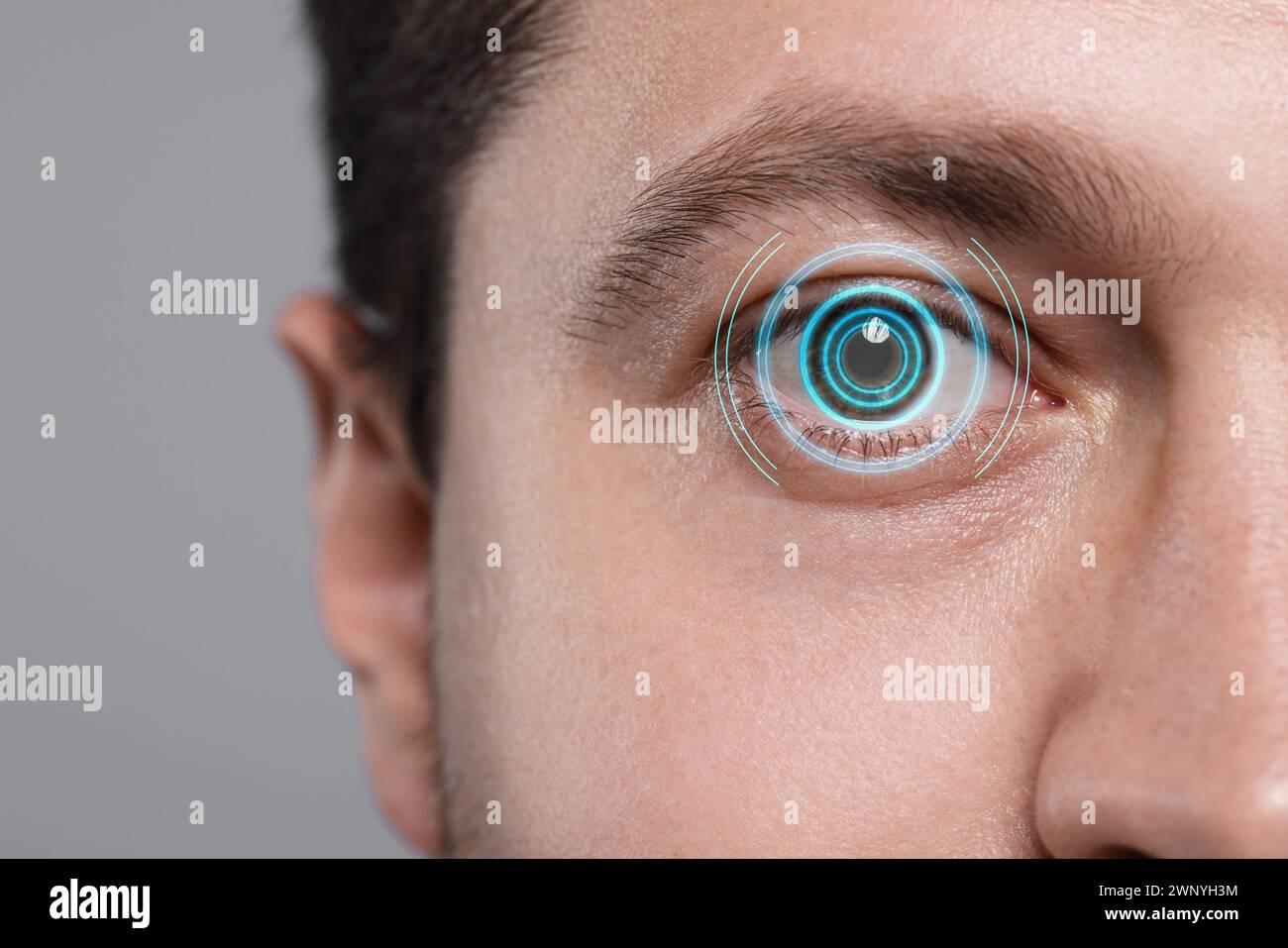 Vision test. Man and digital scheme focused on his eye against grey ...