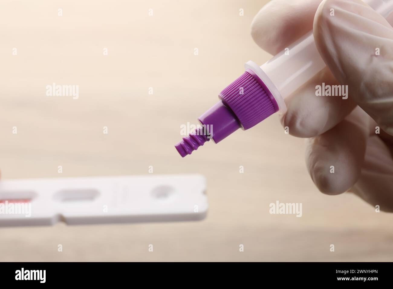 Doctor dropping buffer solution onto disposable express test cassette ...