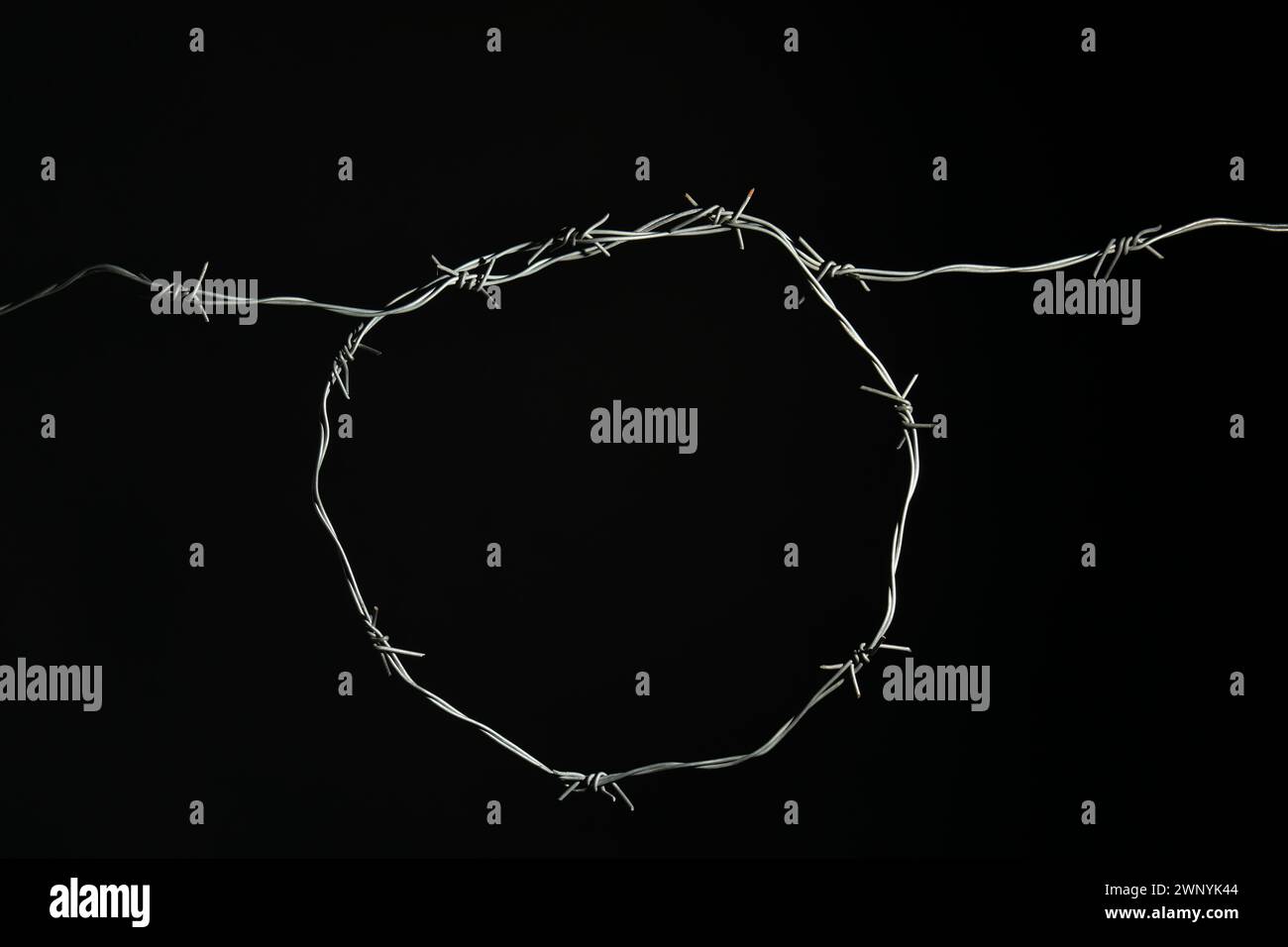 Shiny metal barbed wire on black background Stock Photo - Alamy