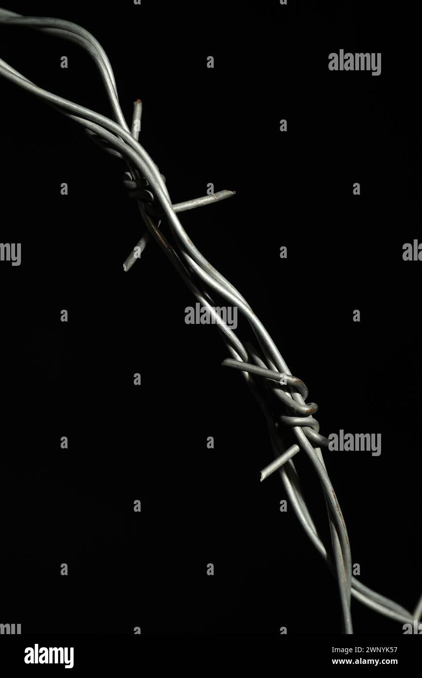 Metal barbed wire on black background, closeup Stock Photo - Alamy