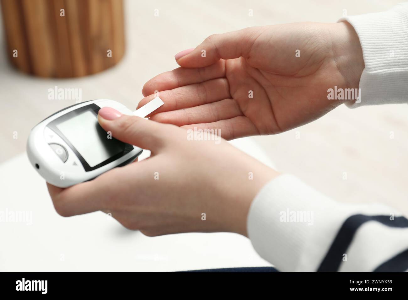 Diabetes. Woman checking blood sugar level with glucometer at home ...