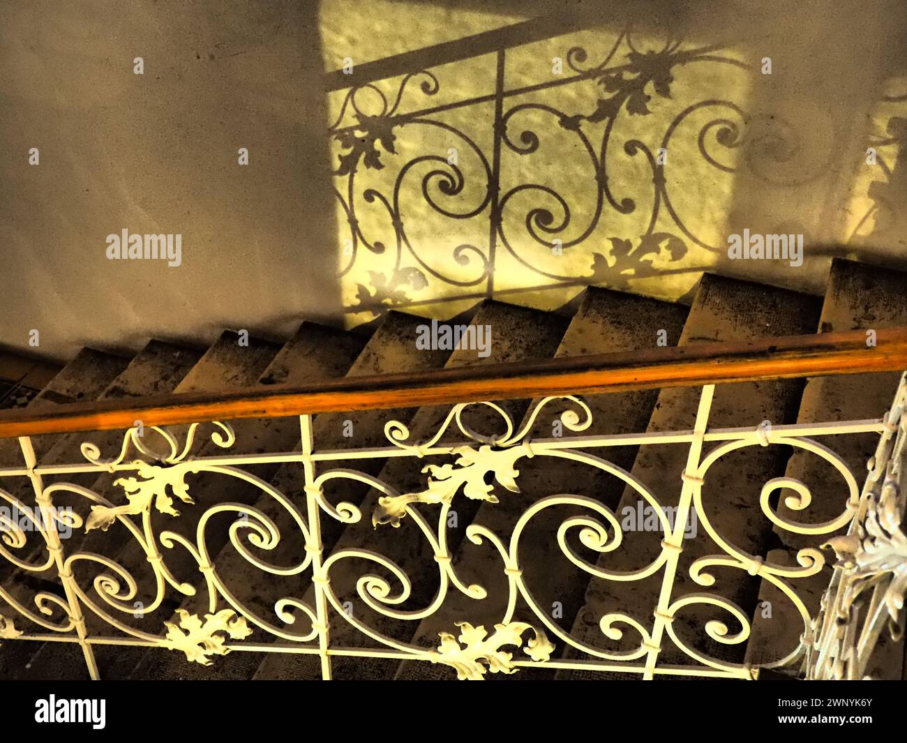 Mysterious staircase with a forged metal railing at night in the dark ...