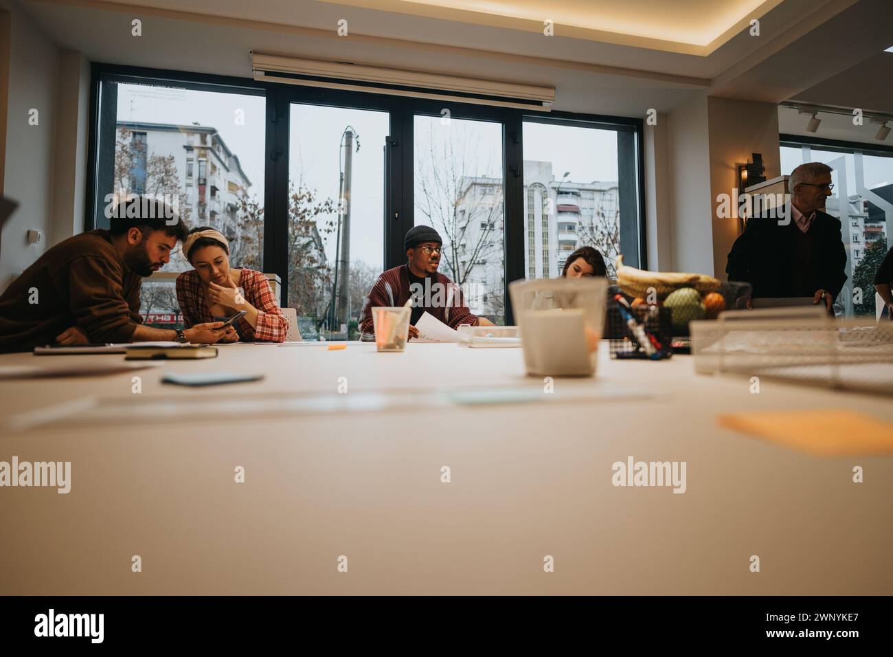 Multi generational team collaborating on project in modern office space ...