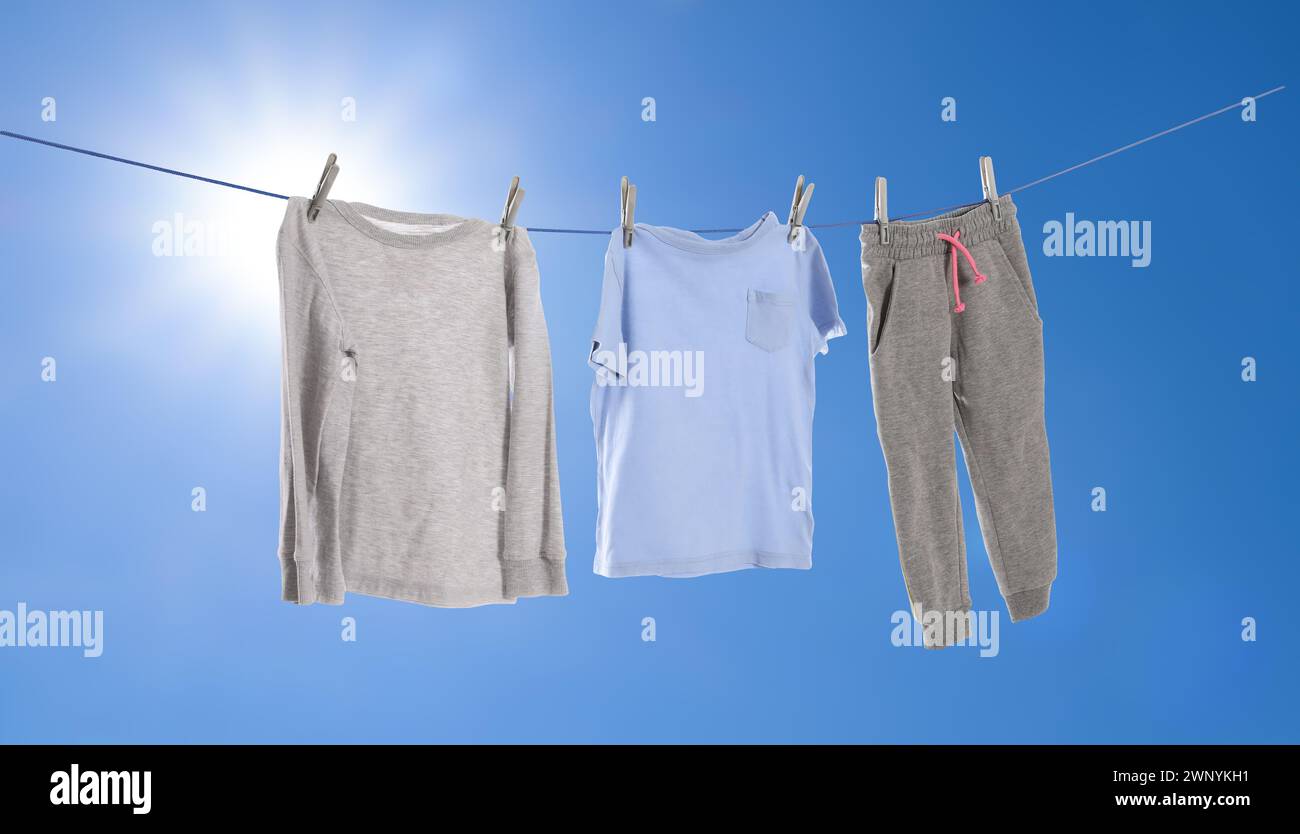 Different clothes drying on washing line against blue sky, banner ...