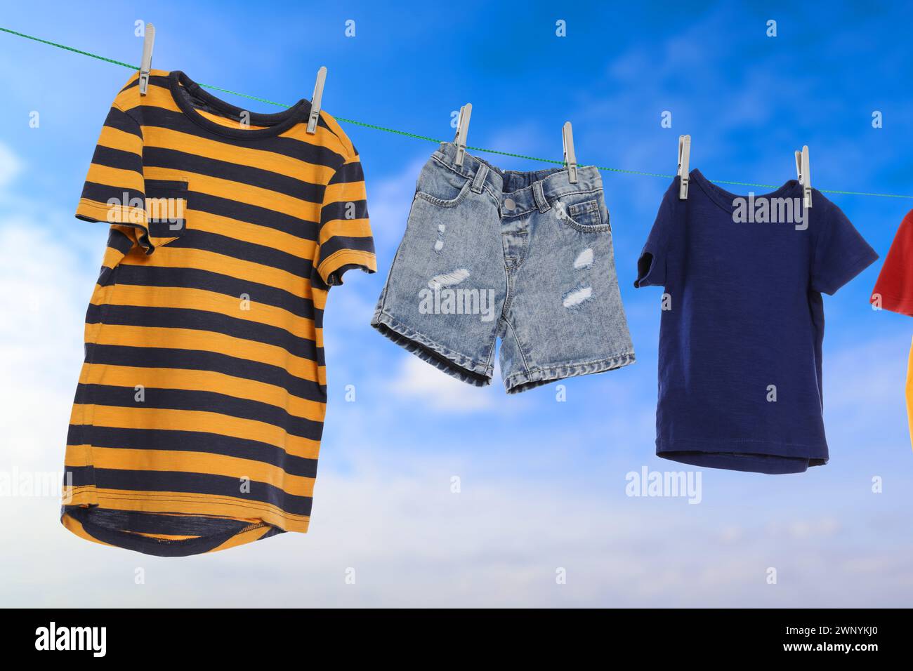 Different clothes drying on washing line against blue sky Stock Photo ...