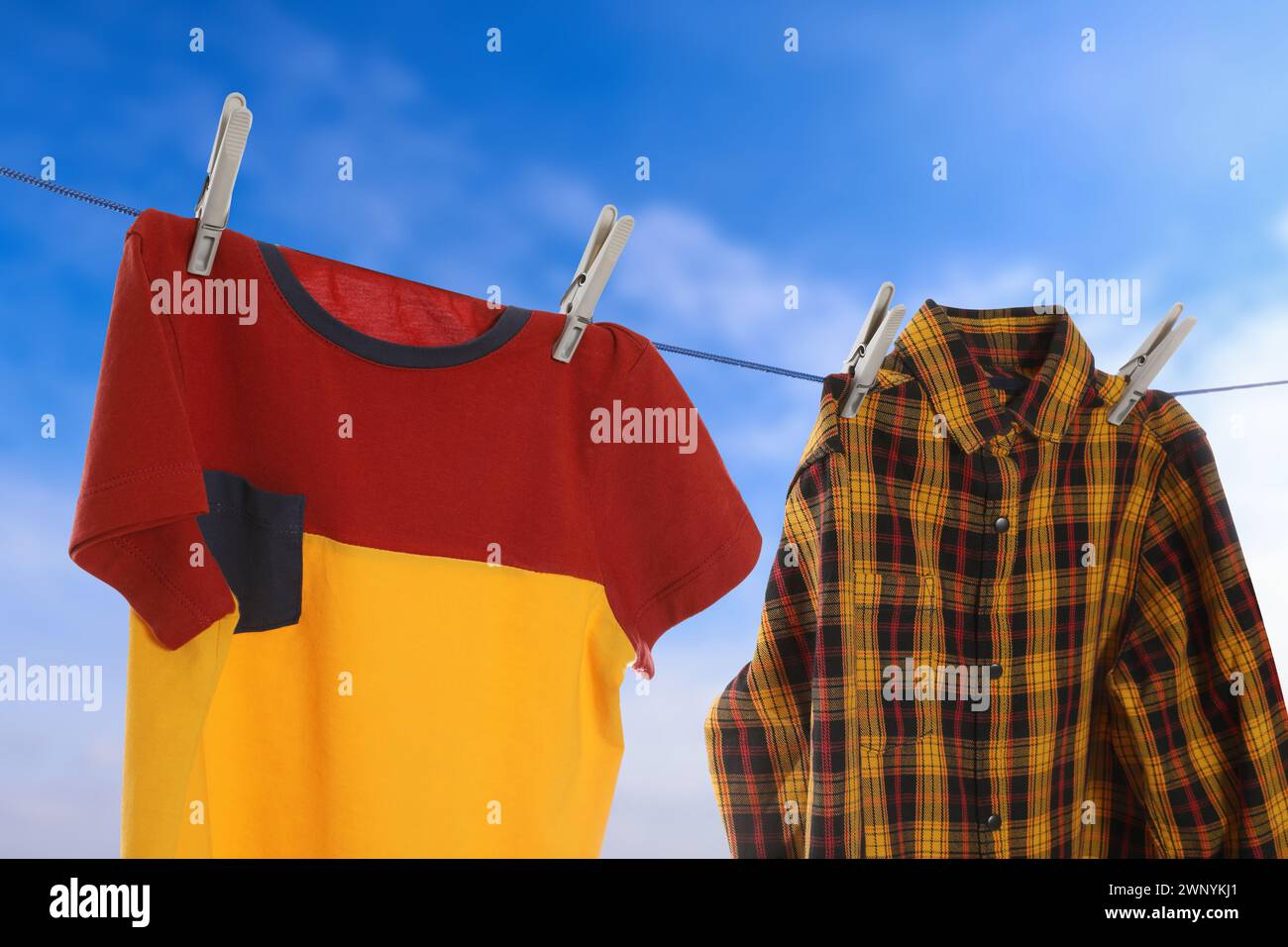 Clothes drying on washing line against blue sky Stock Photo - Alamy