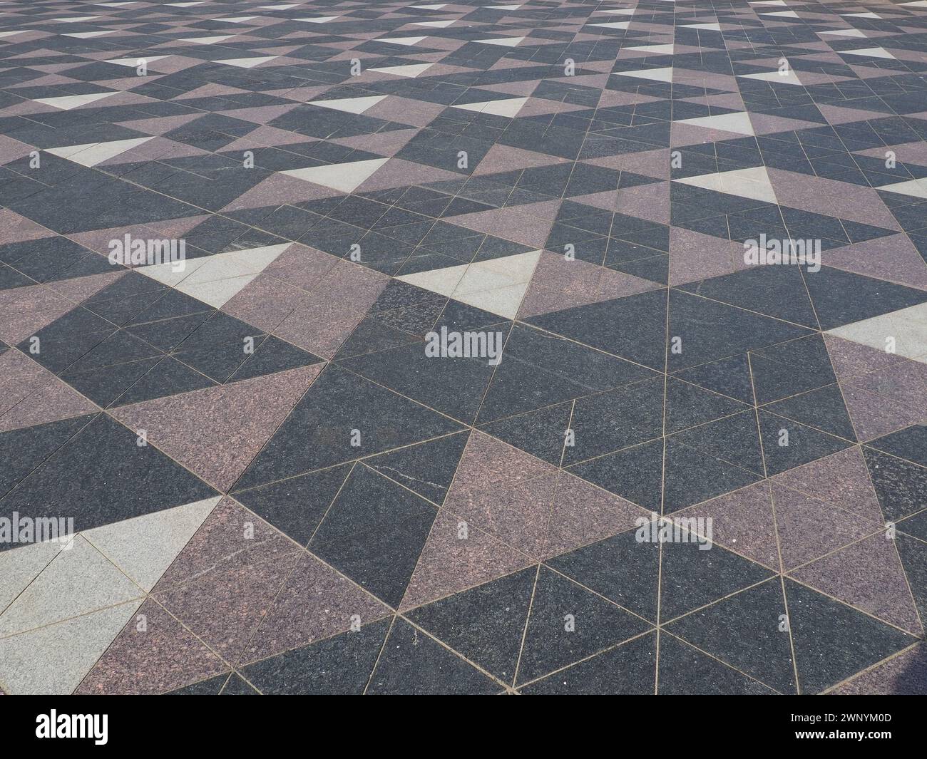 The square is paved with triangular tiles. Grey, white, black tiles on the street. The ...