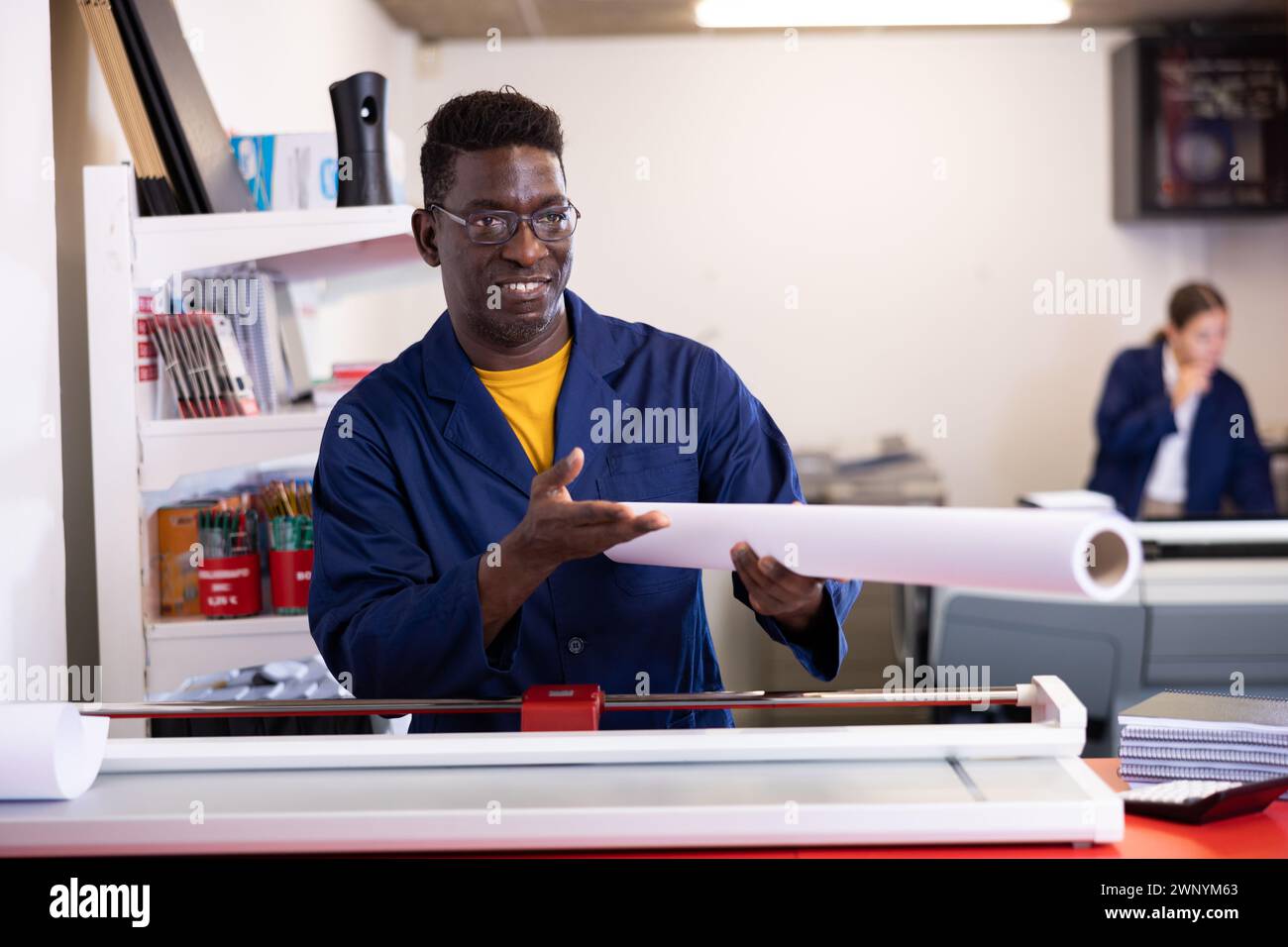 Excited middle-aged African American male typographer in uniform ...