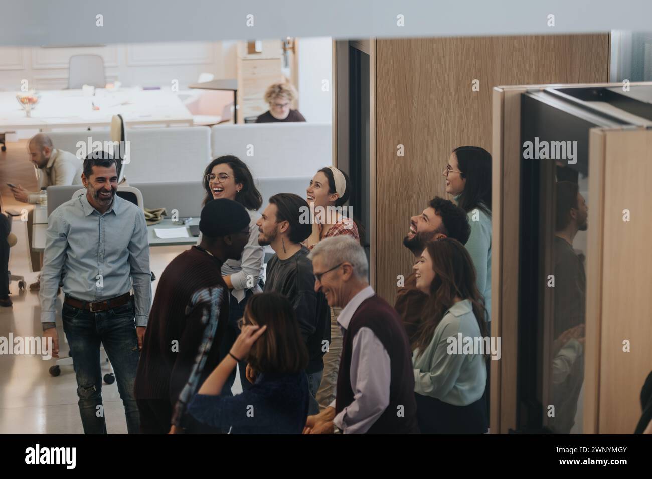 Group of diverse colleagues laughing in a casual office environment ...