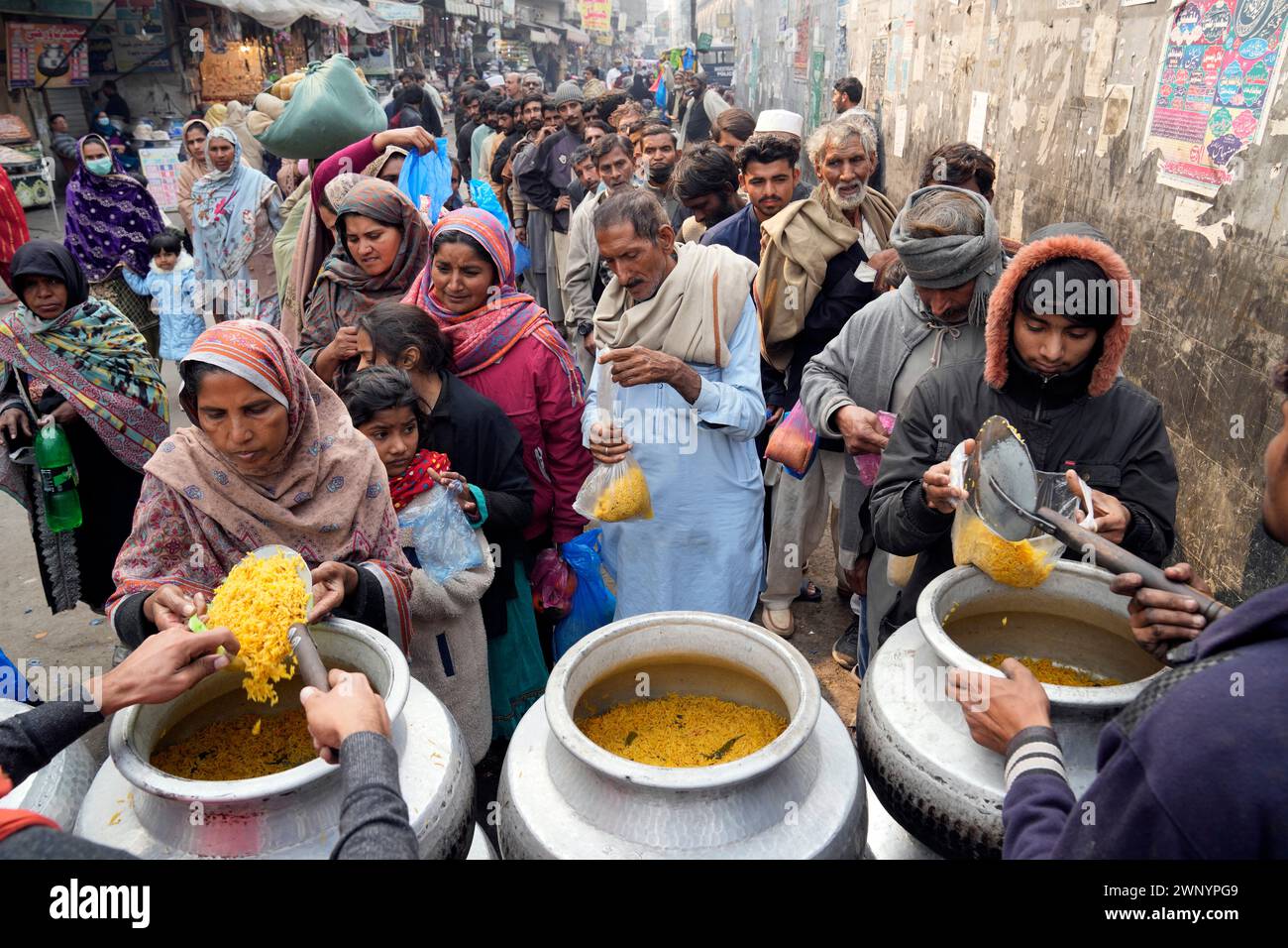 Pakistani people receive free food outside the Data Darbar shrine in ...