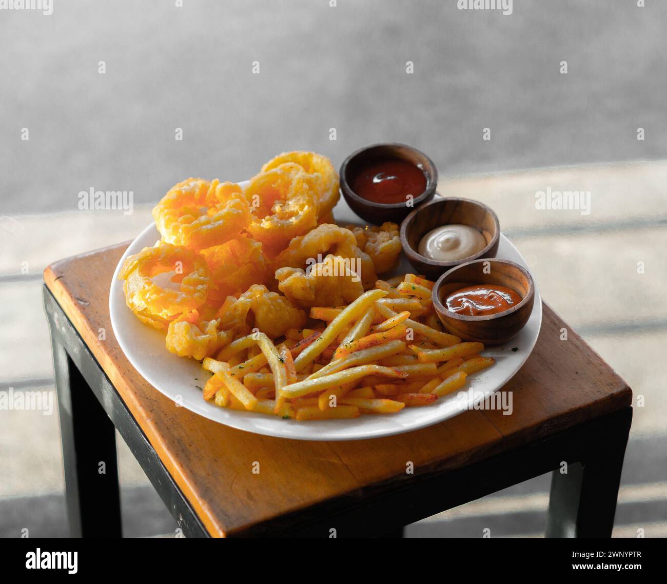 a plate consisting of fried calamari, french fries and popcorn chicken ...