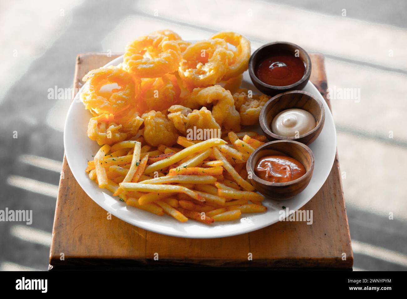 a plate consisting of fried calamari, french fries and popcorn chicken ...