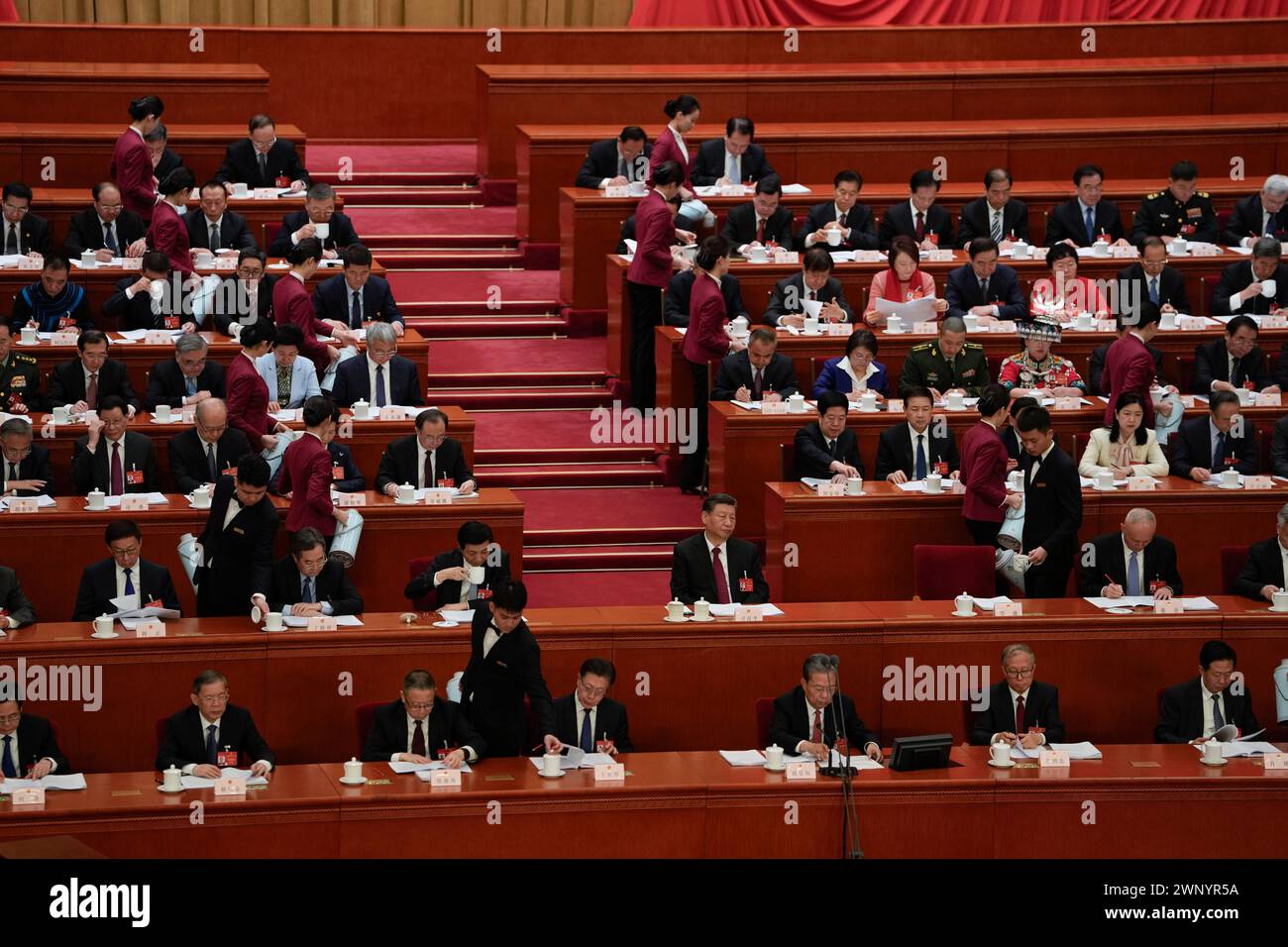 Attendants serve tea to the delegates during the opening remark by ...
