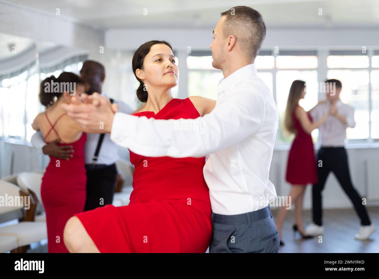 Man and Asian woman dancing tango in couple during lesson at studio Stock Photo - Alamy