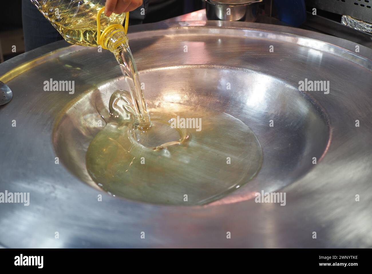 pouring cooking oil in a large cooking pan Stock Photo - Alamy