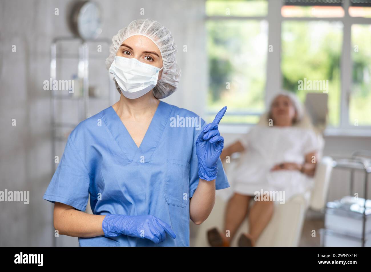 Happy doctor or nurse with mask in uniform with crossed arm, patient ...