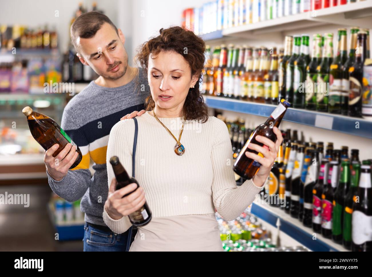 Portrait of a married couple buying beer in liquor store Stock Photo ...