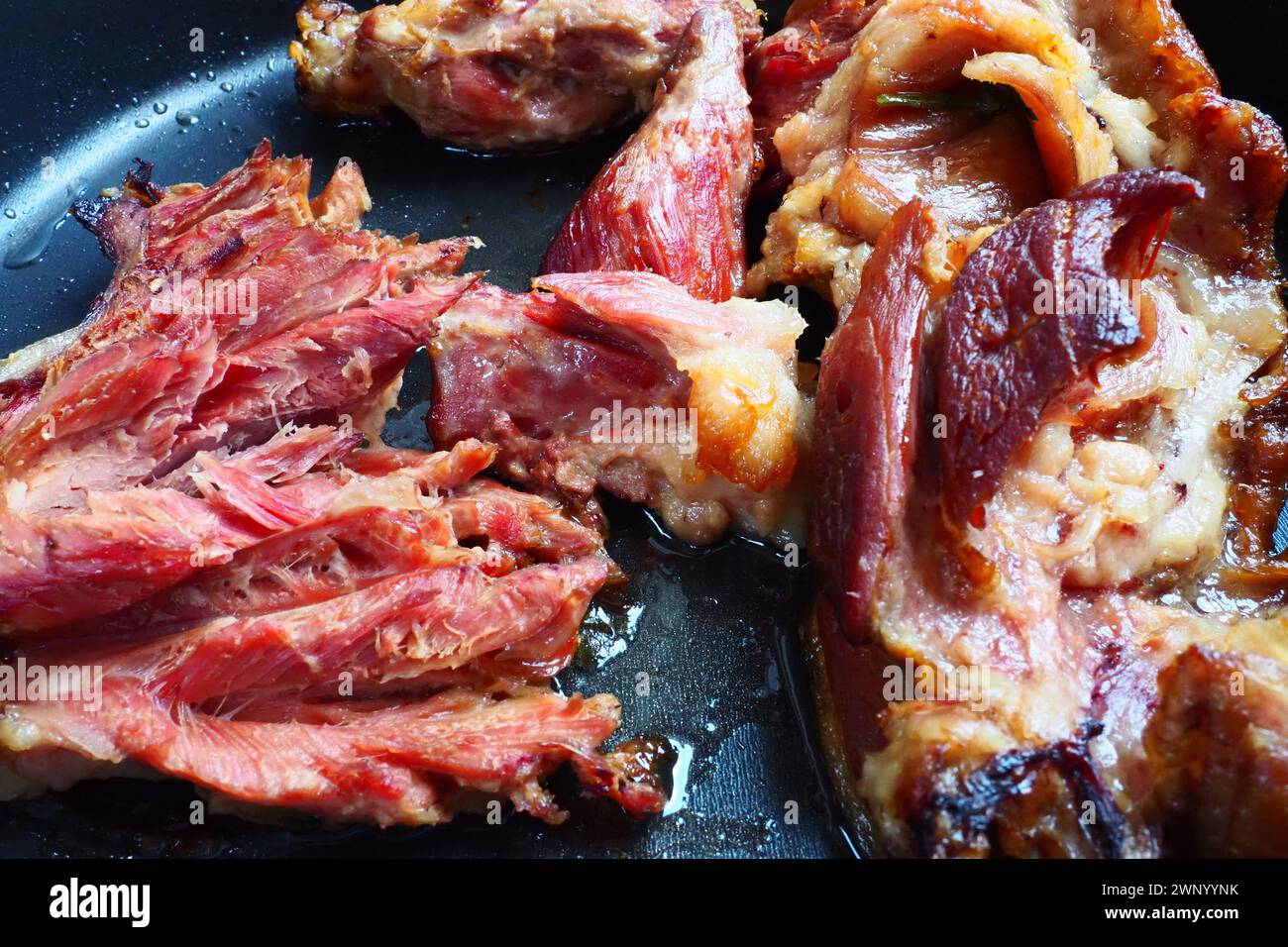 Roasted smoked pork shoulder or knee. Delicious meat on a black baking ...