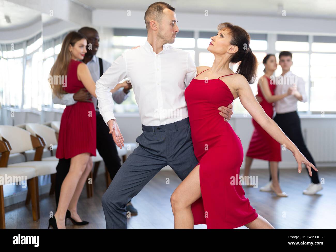 Young man and woman dancing tango in couple during lesson at studio Stock Photo - Alamy